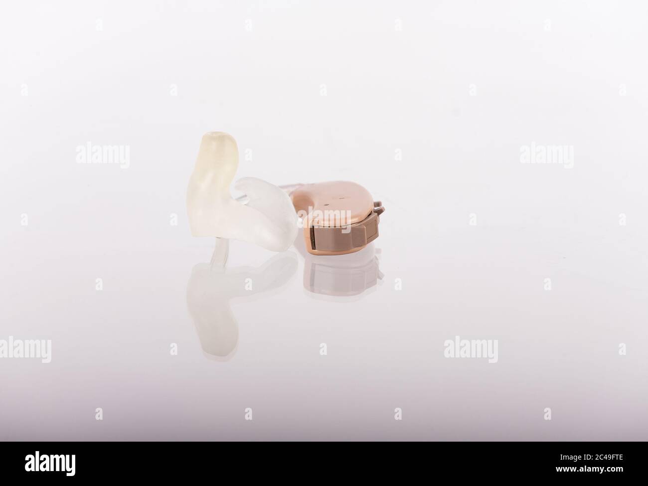 Hearing aid with earmold on a reflecting glass surface Stock Photo - Alamy