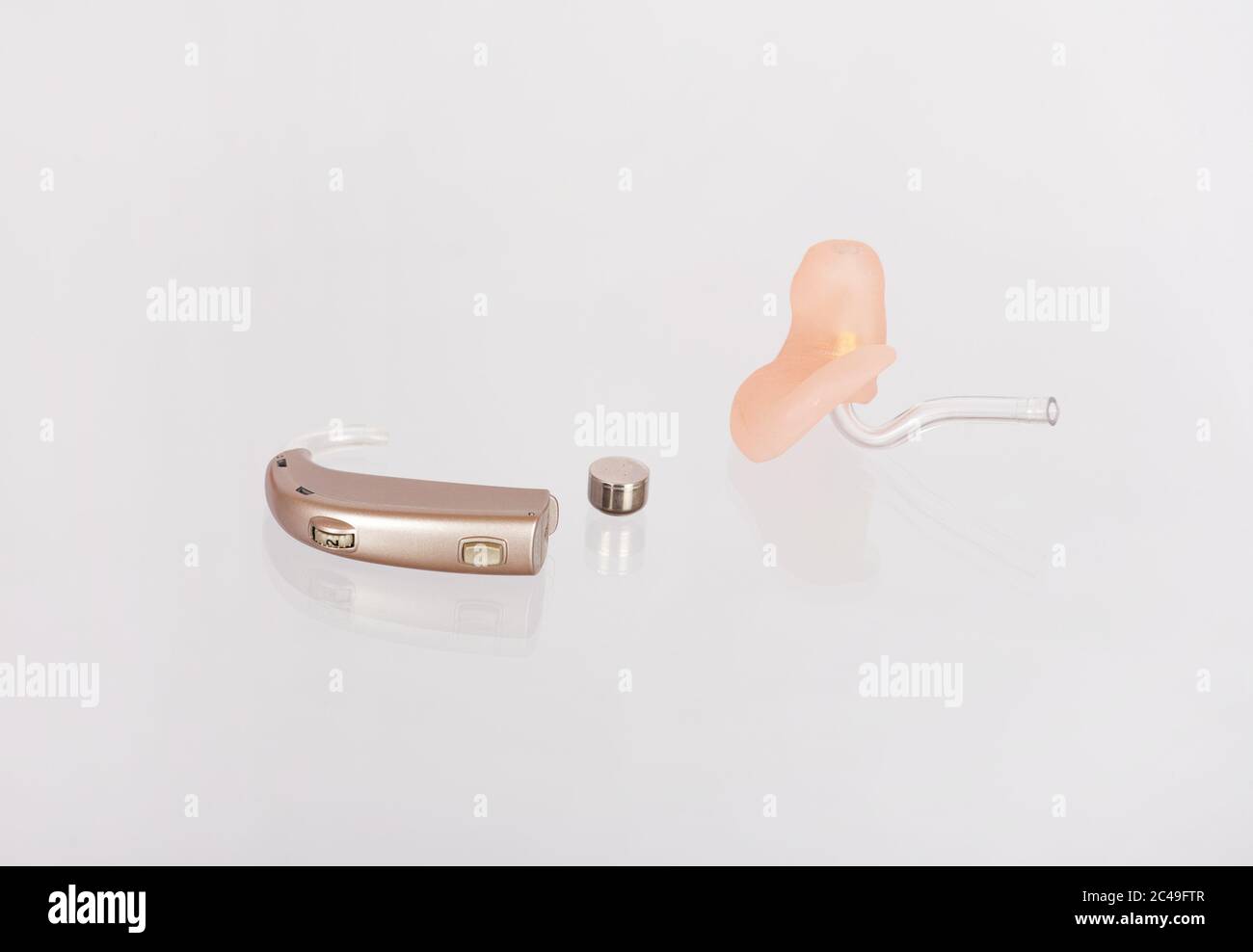 Hearing aids, ear mould and a battery with their reflections Stock ...