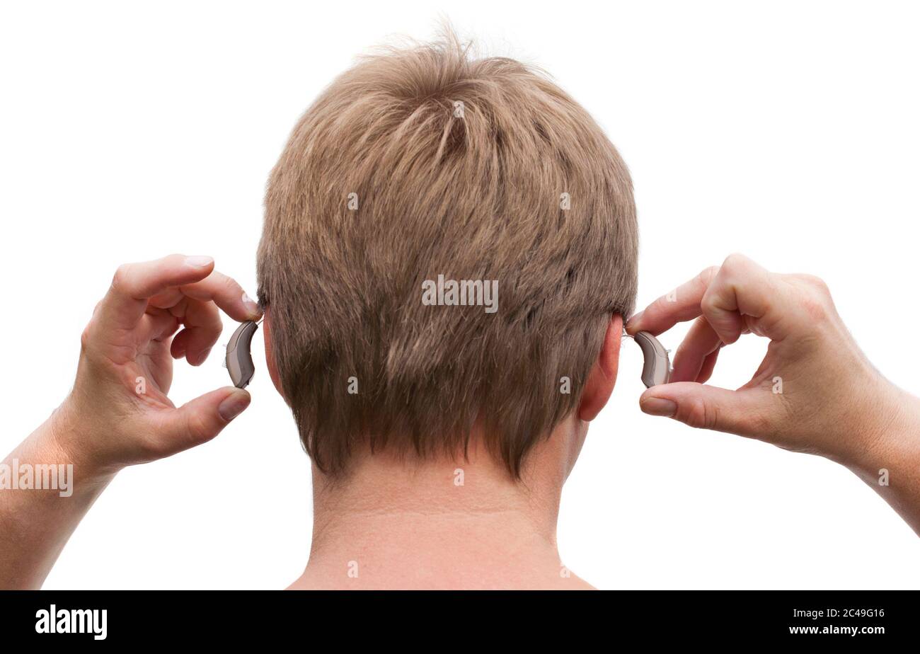 Back view of a deaf man's head and hands putting on his behind-the-ear ...