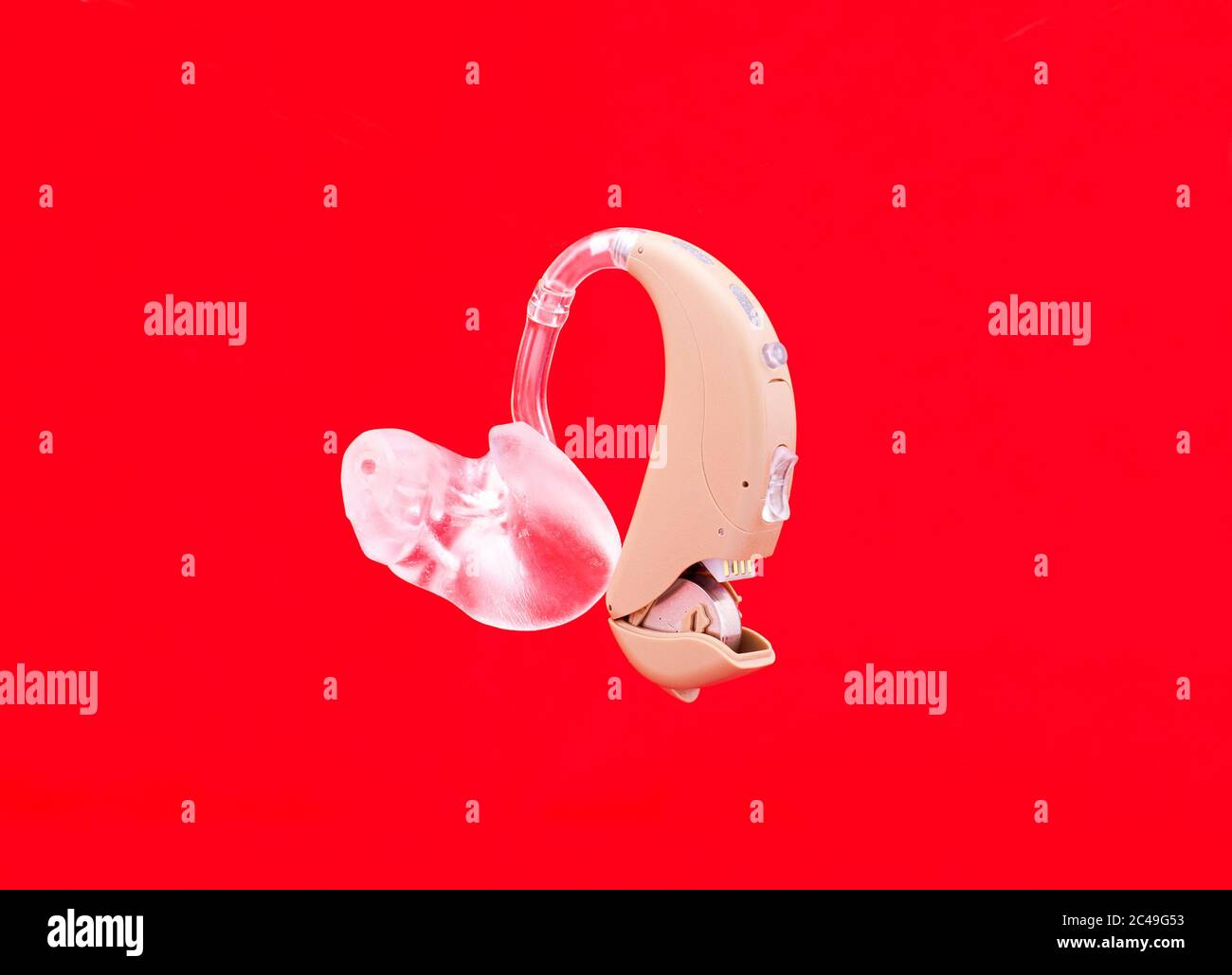 Hearing aid with earmold in front of a vivid red background Stock Photo ...