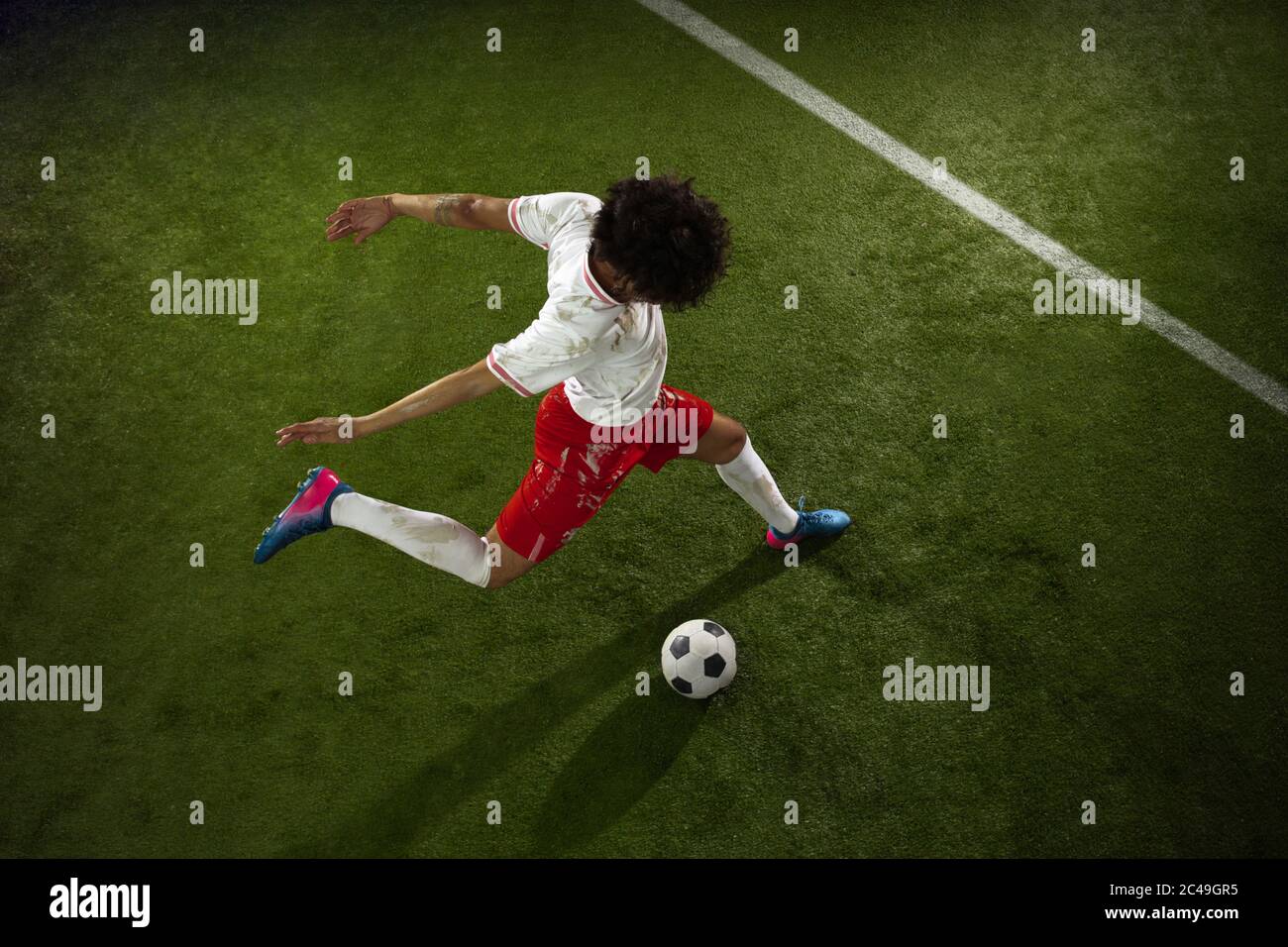 Top view of caucasian football or soccer player on green background of ...