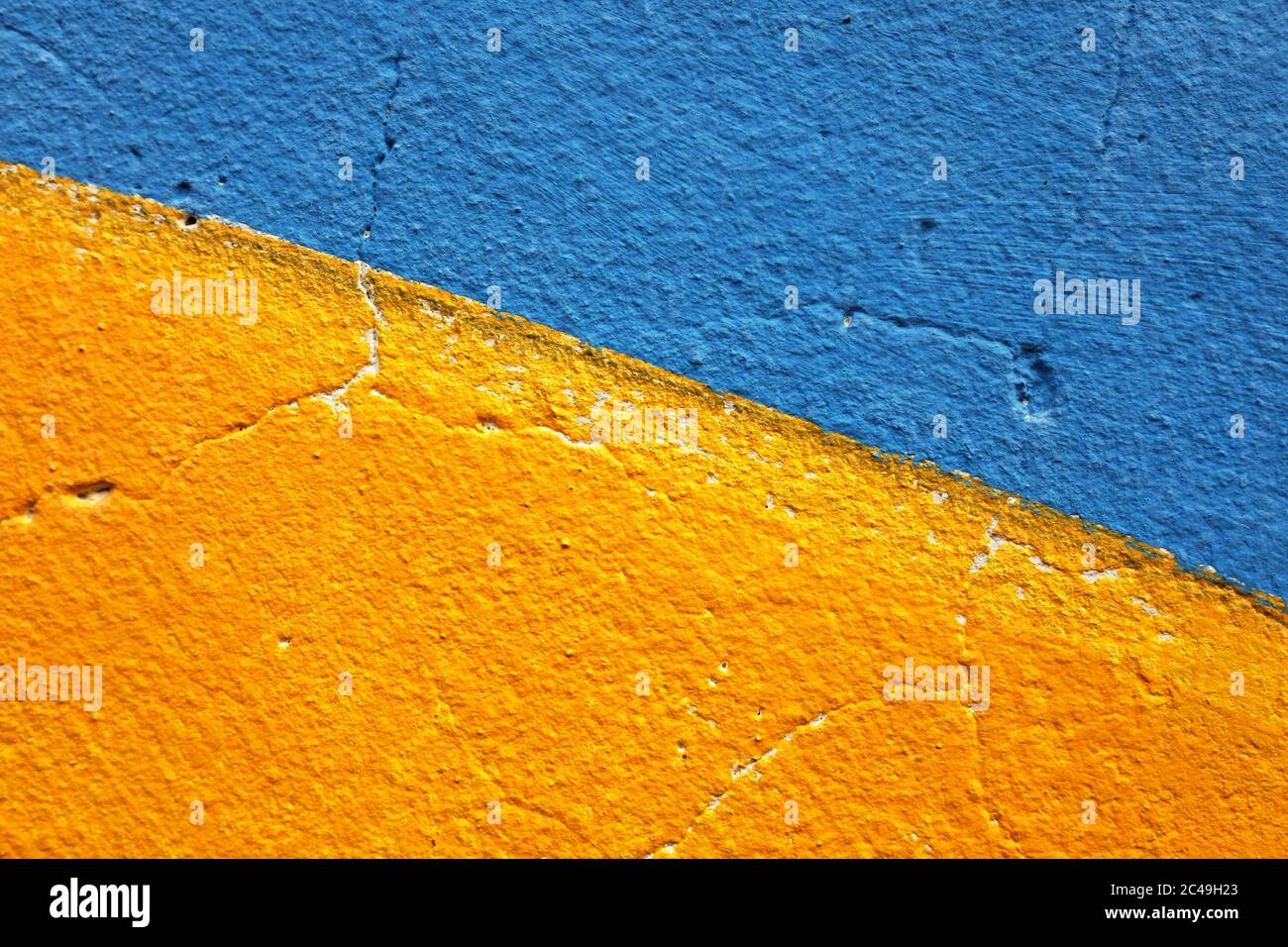 Half of blue and half of yellow painted grunge wall without gradient ...