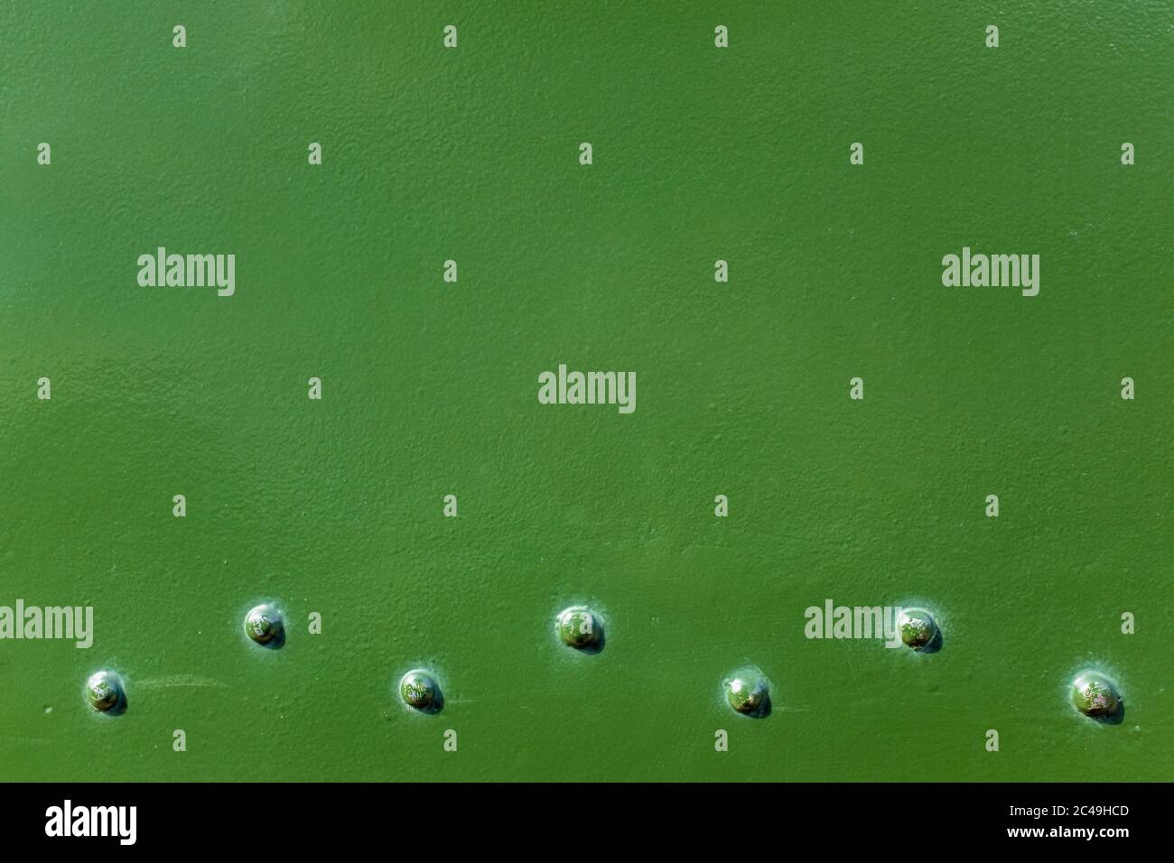 Green painted grainy metal plate with rivets at the bottom for ...