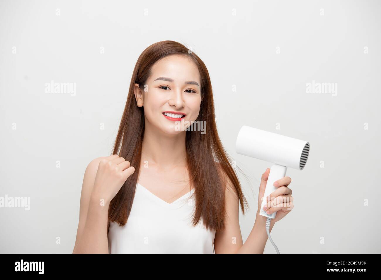 Beautiful Asian girl drying her hair with hairdryer Stock Photo - Alamy