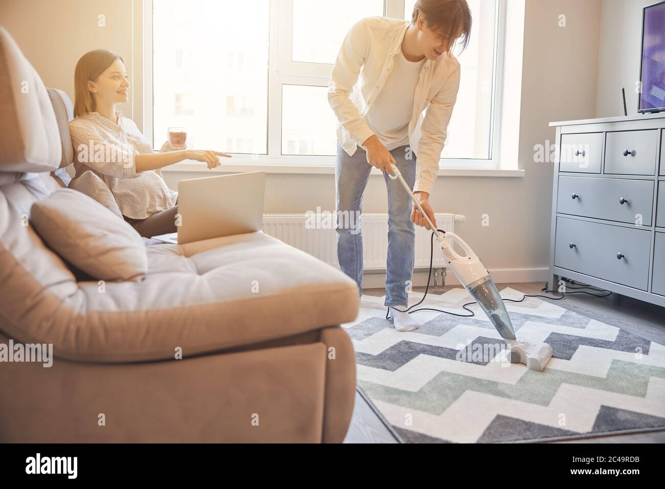Mirthful couple at home enjoying daily routine and housework Stock ...