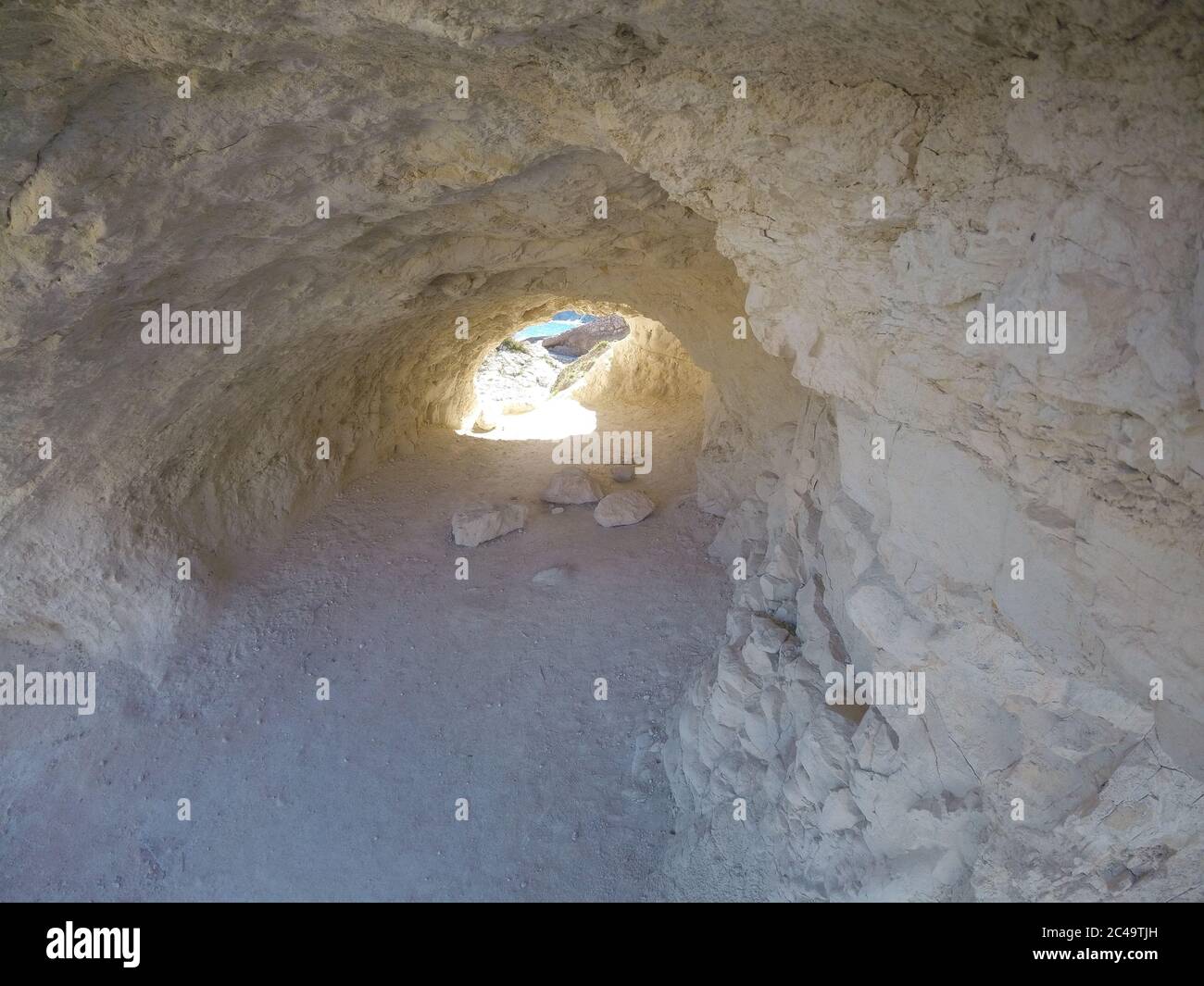 Small natural cave made of white stone going towards the beach and the ...