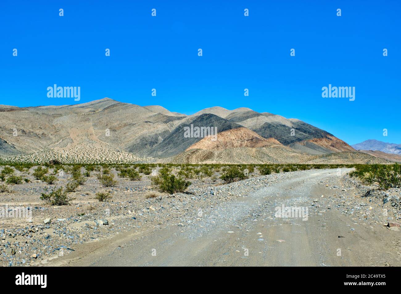 Road against the backdrop of mountains in the death valley Stock Photo ...