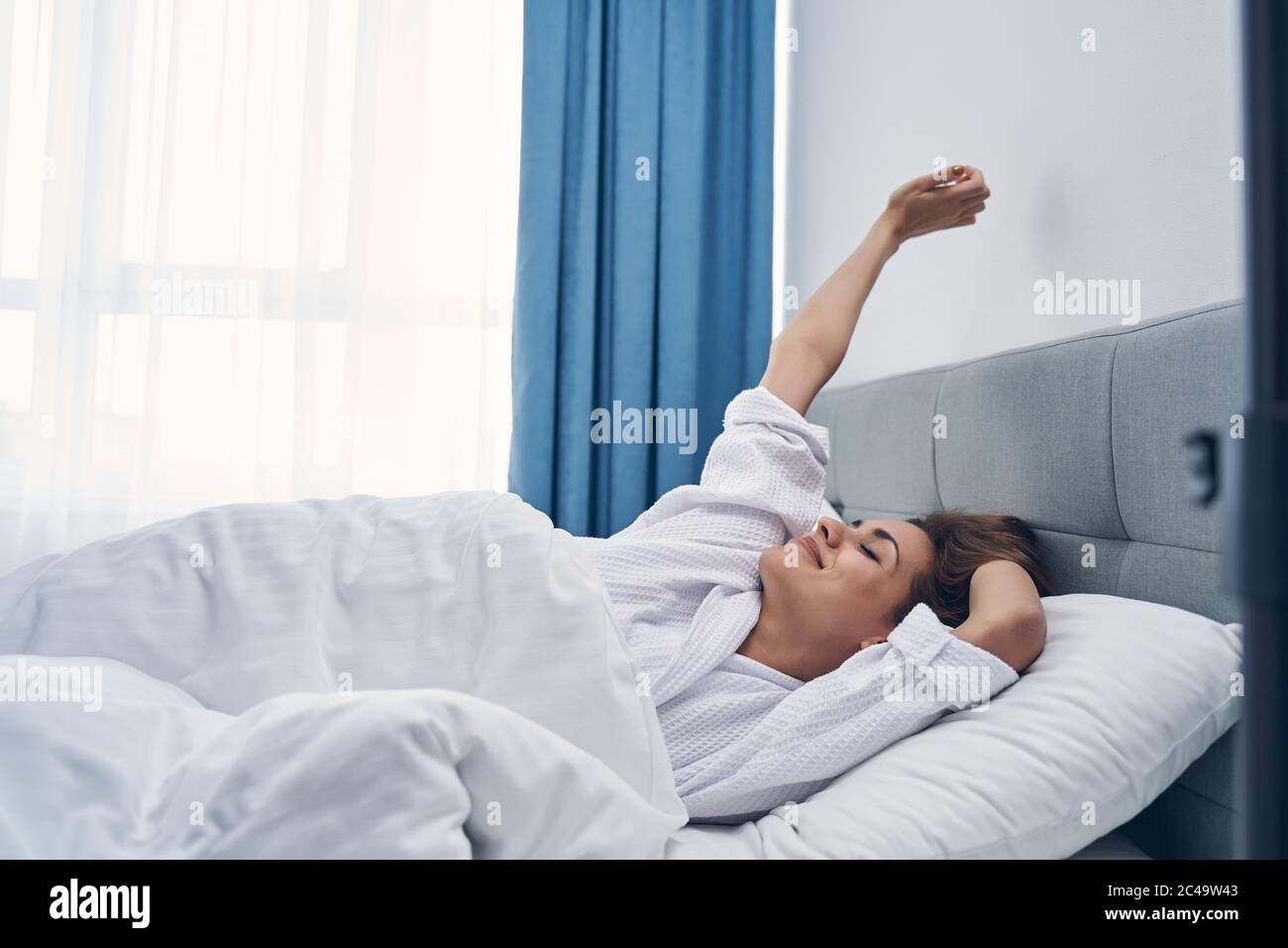 Beautiful young woman waking up in her bedroom Stock Photo - Alamy