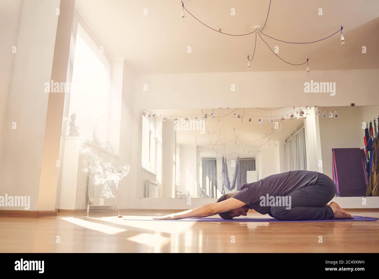 Athletic young man doing child pose or balasana Stock Photo - Alamy