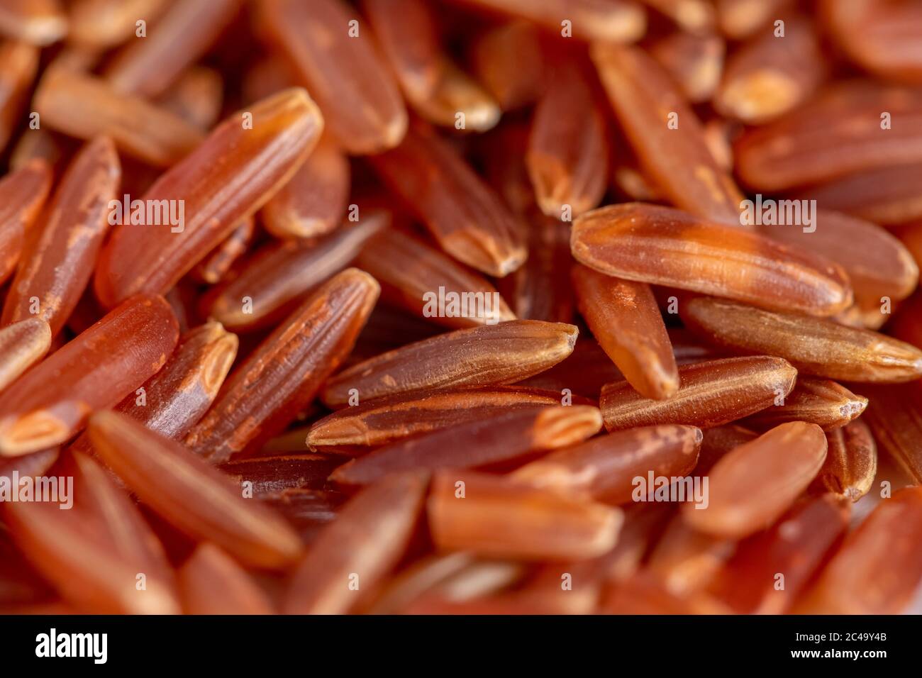 Texture of raw long grains of red rice, healthy food Stock Photo - Alamy