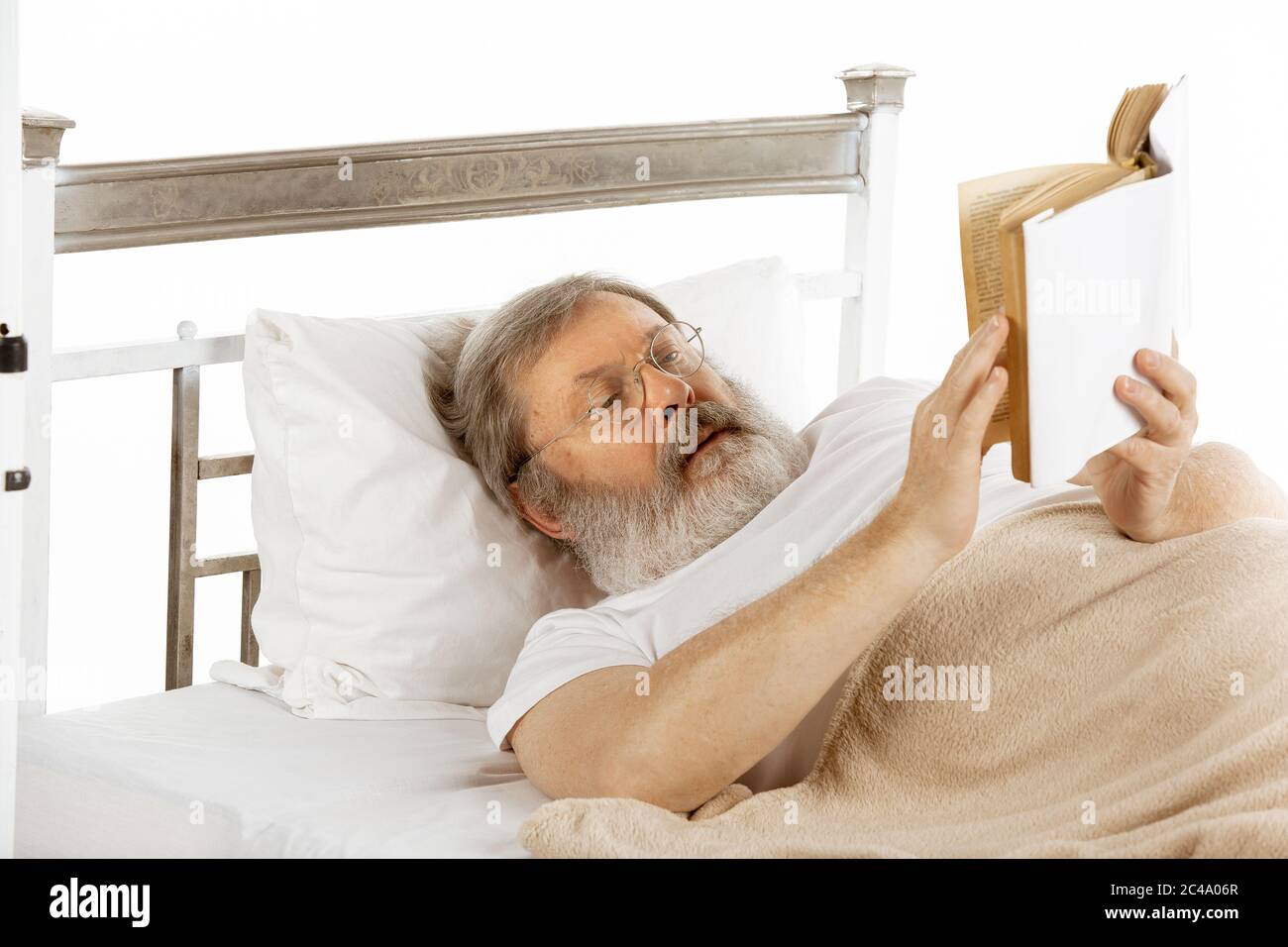 Elderly old man recovering in a comfortable hospital bed isolated on ...