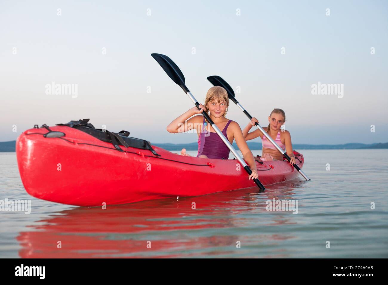 Girls with paddle and kayak on a lake at sunset Stock Photo - Alamy