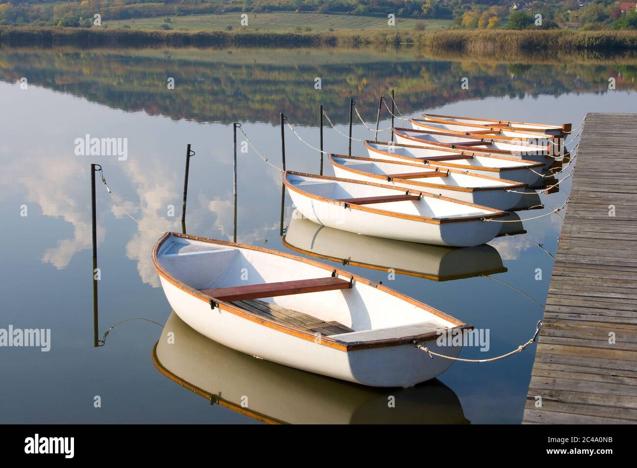 White boats floating on the calm water surface at a wood jetty Stock ...