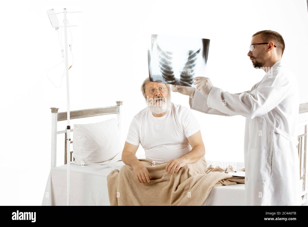 Elderly old man recovering in a hospital bed isolated on white ...