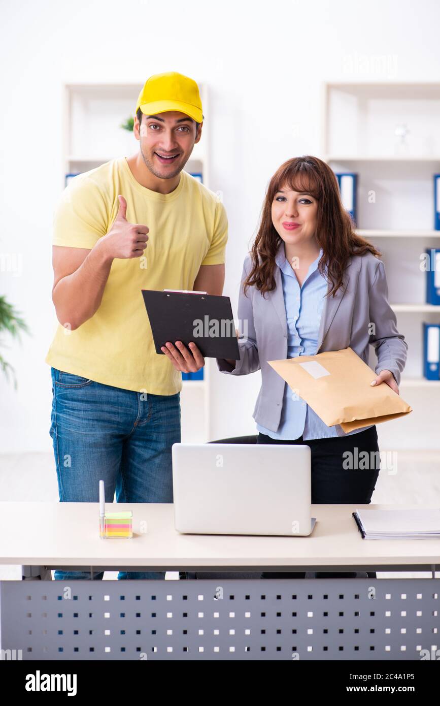 Young courier delivering parcel to the office Stock Photo - Alamy