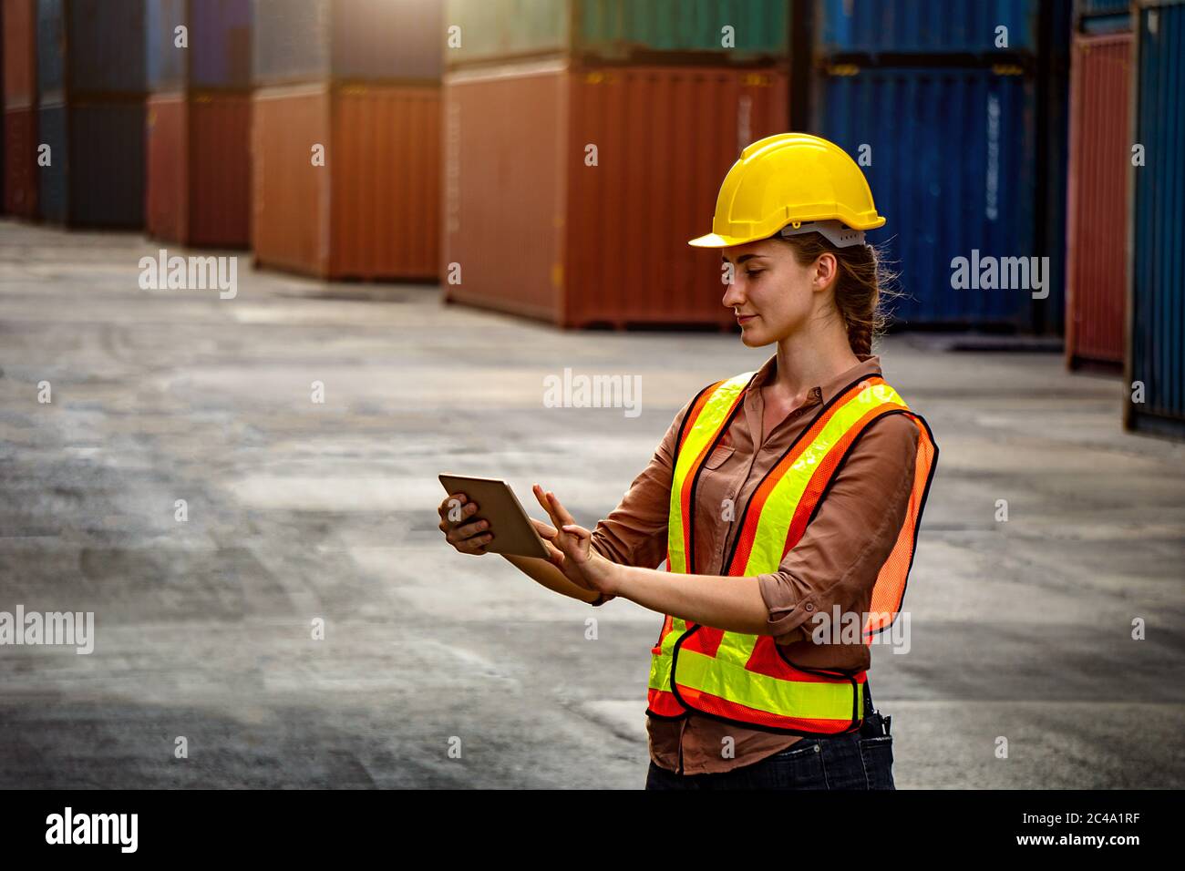 Female foreman is using computer tablet to control work in industrial ...