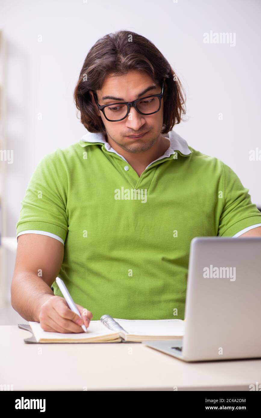 Young male student in the classroom studying Stock Photo - Alamy