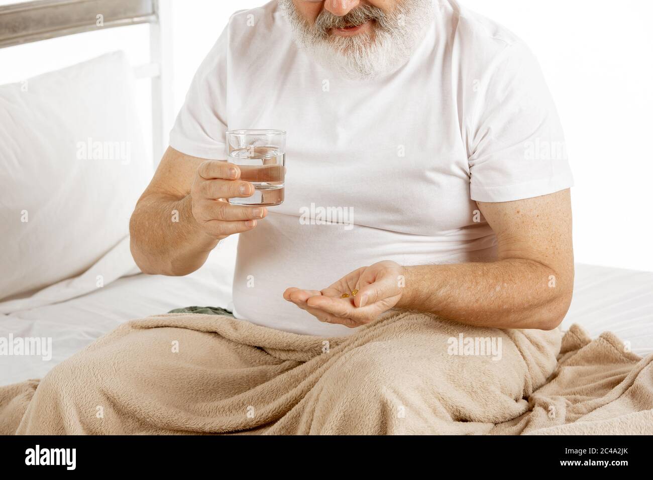 Elderly old man recovering in a hospital bed isolated on white ...