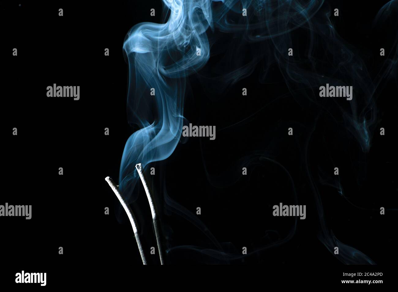 White puffed smoke coming out of sticks in a dark background Stock ...