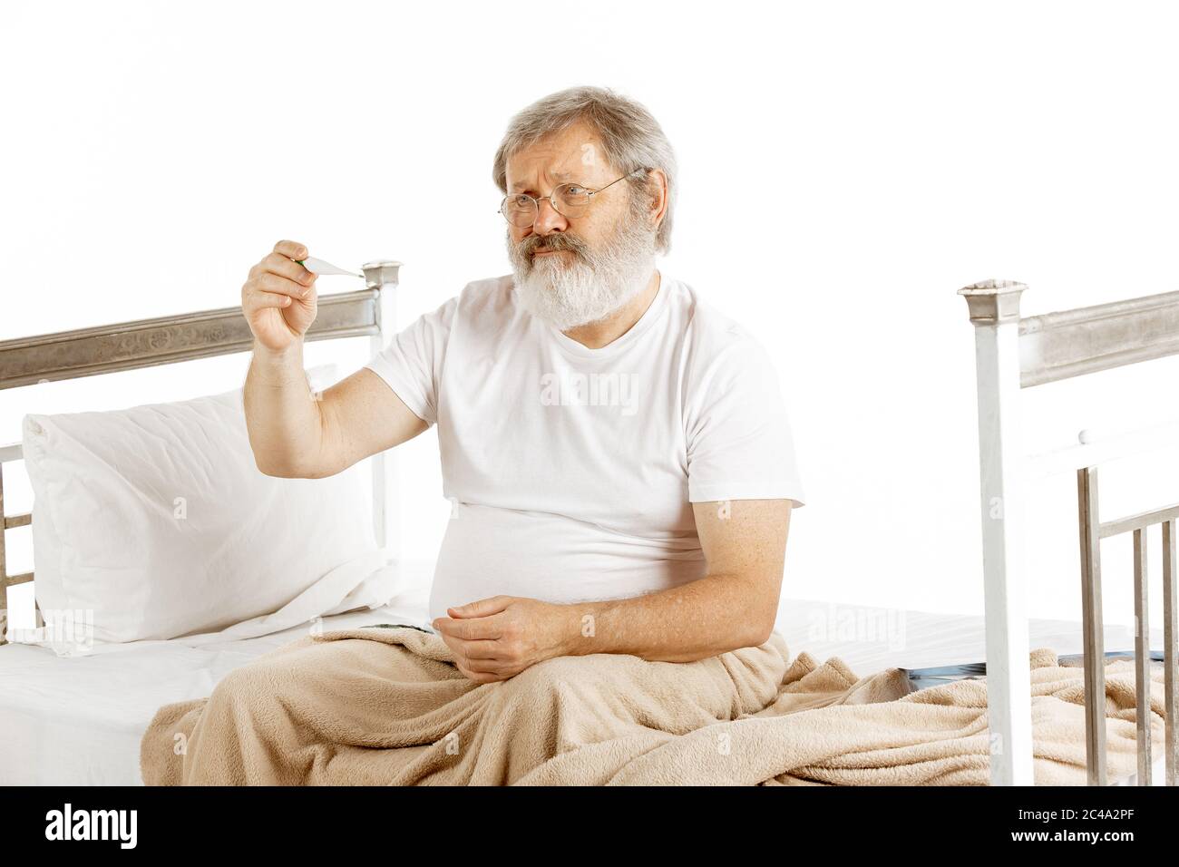 Elderly old man recovering in a hospital bed isolated on white ...