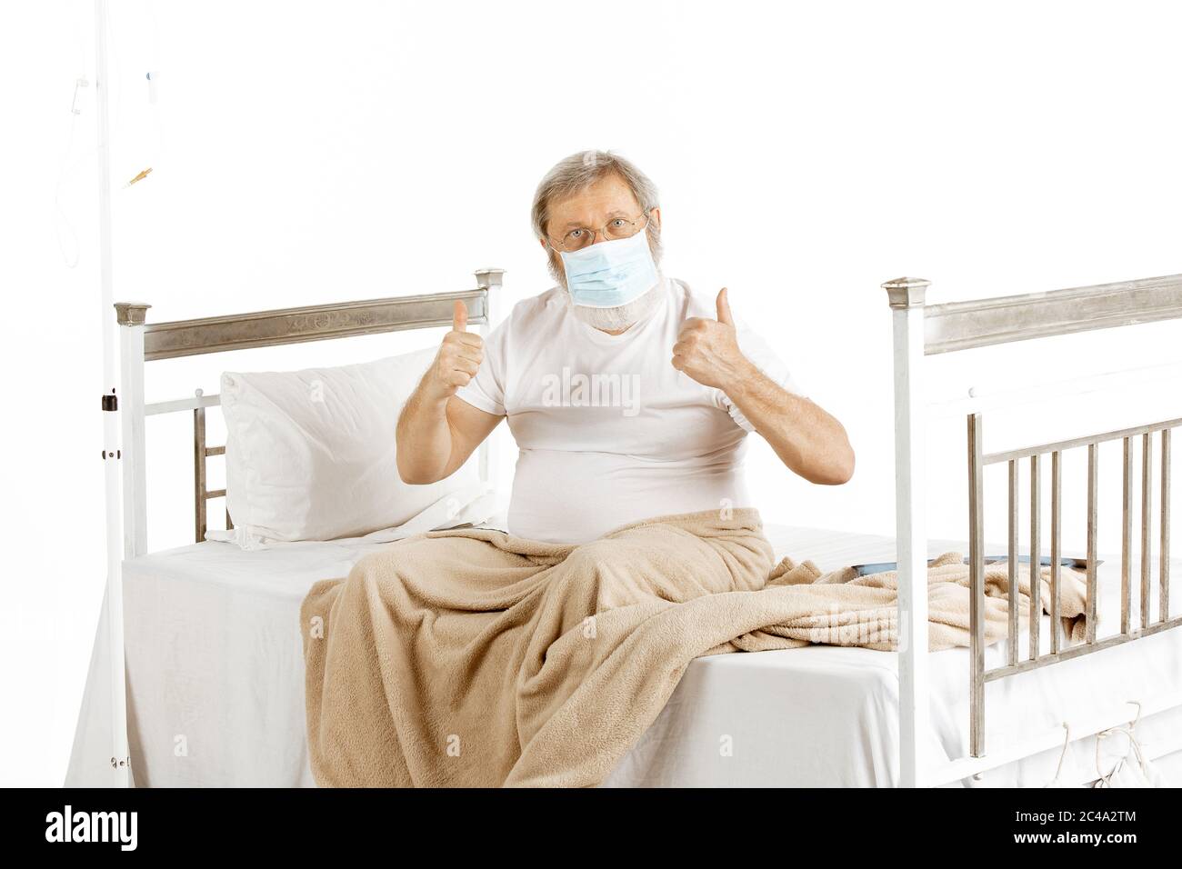 Elderly old man recovering in a hospital bed isolated on white ...