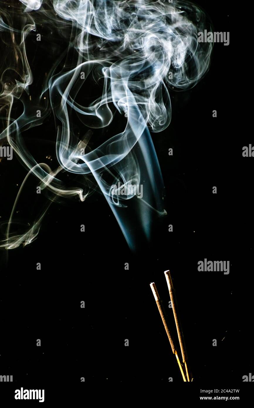 White puffed smoke coming out of sticks in a dark background Stock ...
