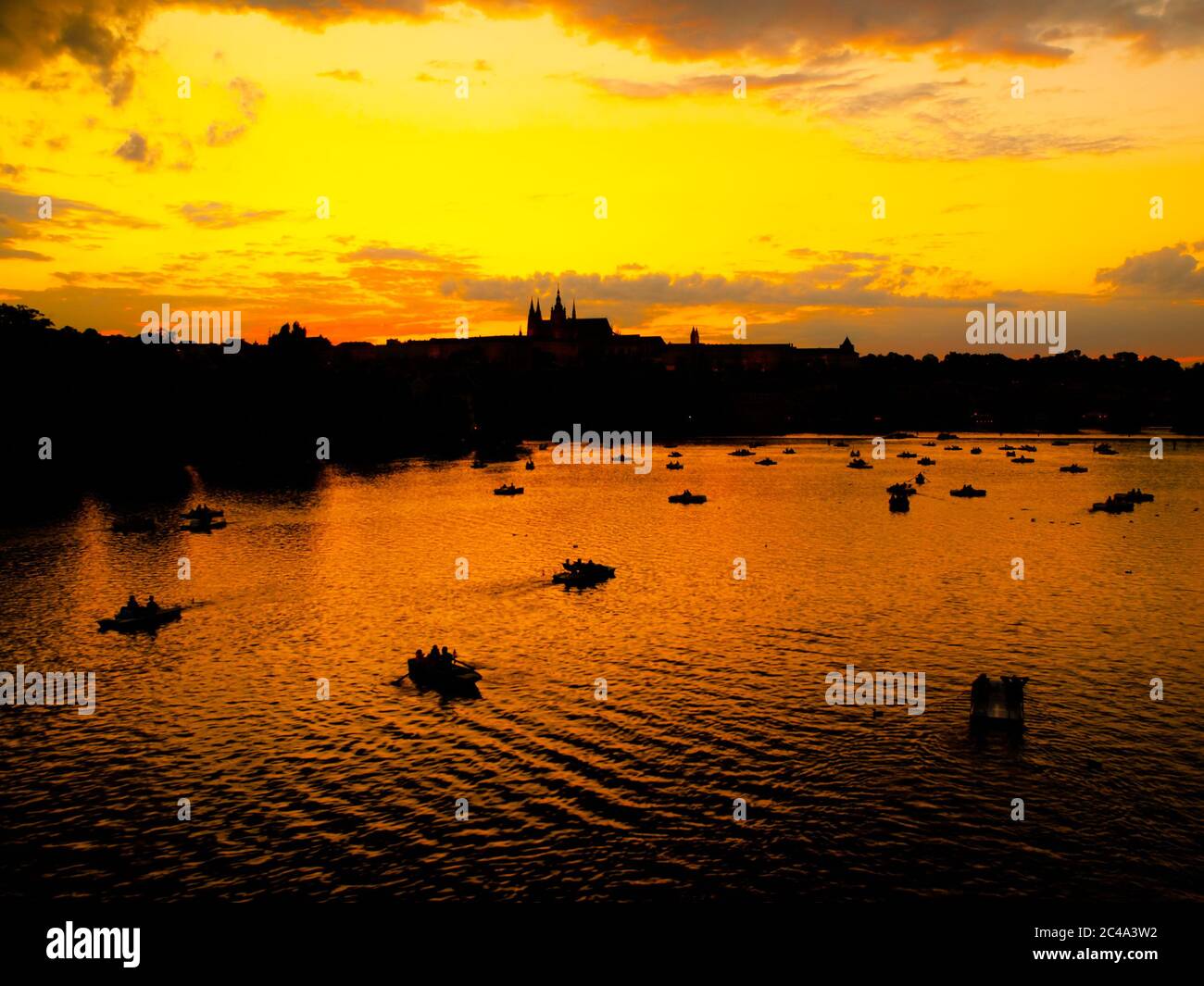 Pedal boats on Vlatava river. Golden evening sunset with Prague Castle ...