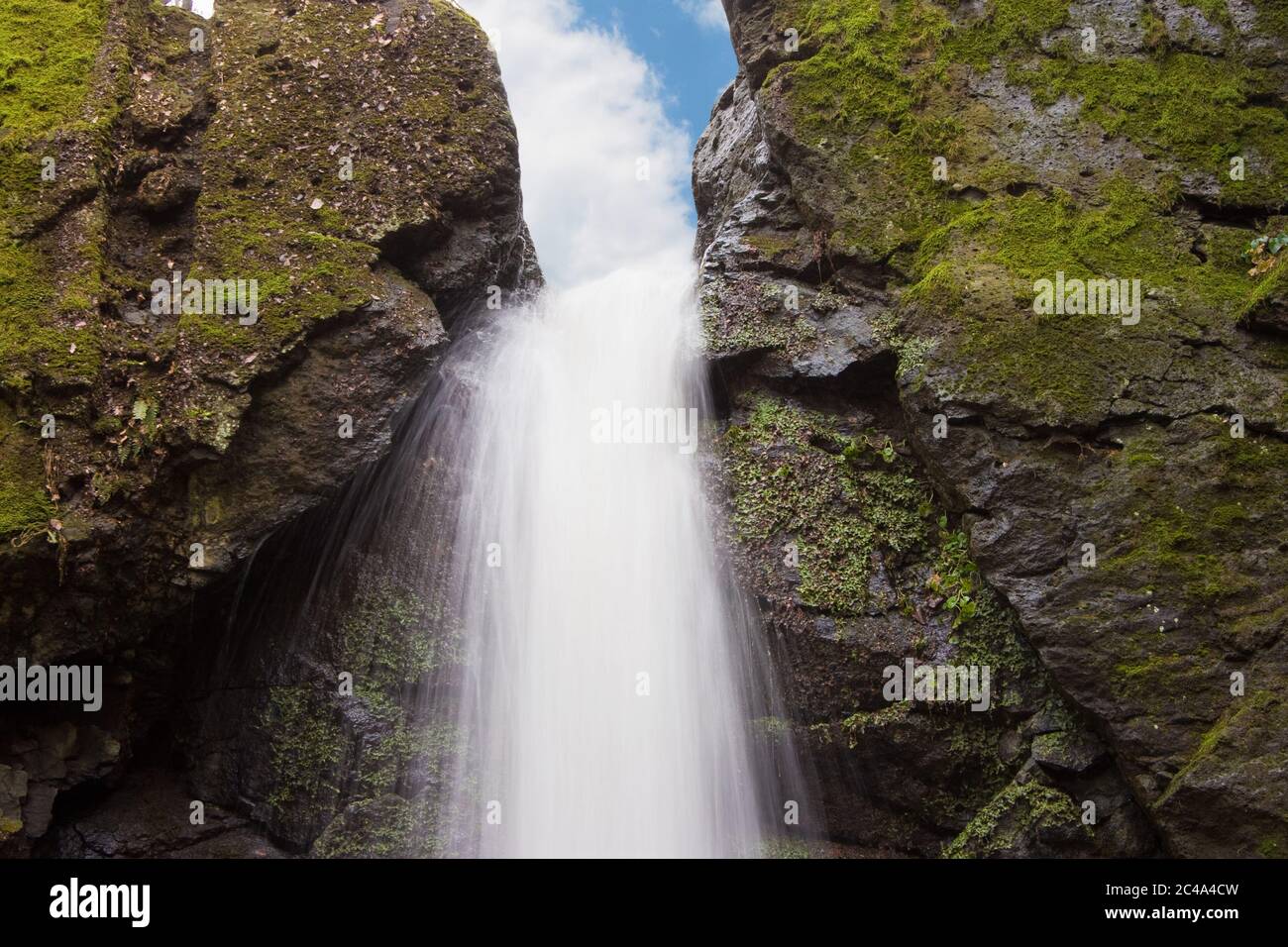 Waterfall breaks through a narrow gap between stones Stock Photo - Alamy
