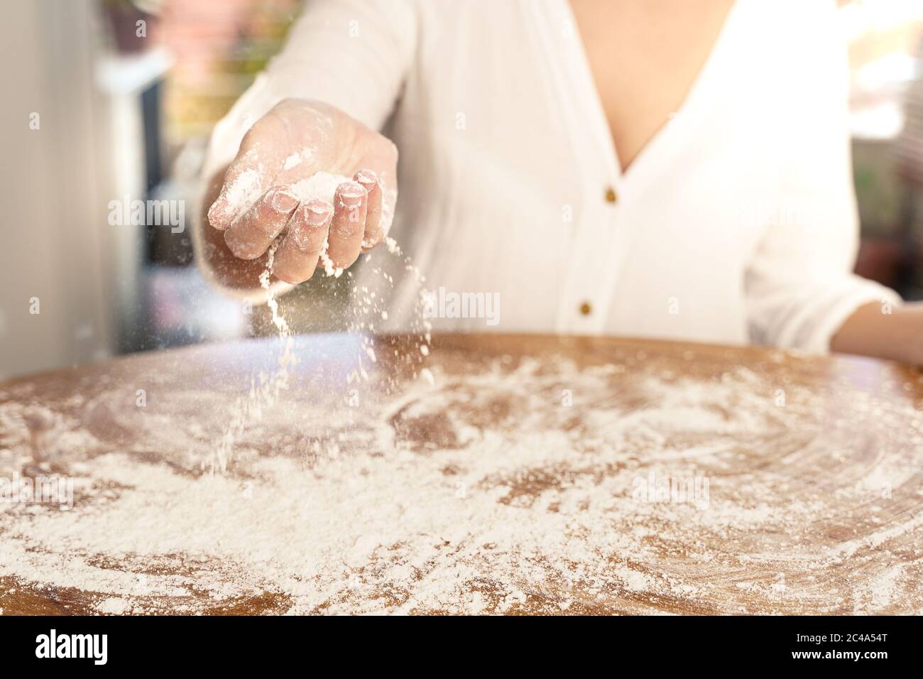 Hands of a woman sprinkling flour on the table Stock Photo - Alamy