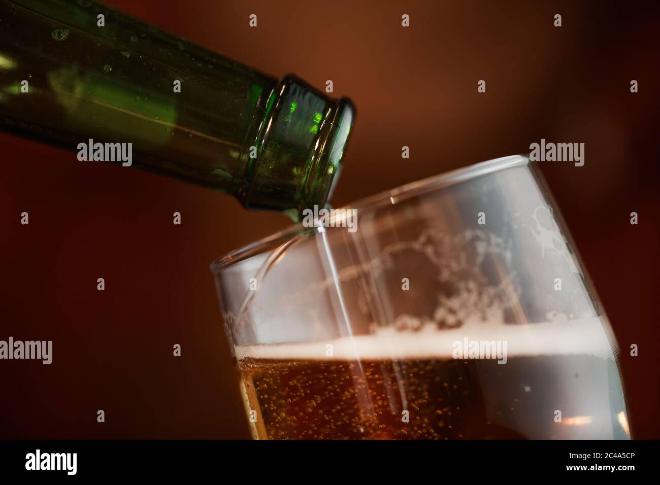 Close-up of cold beer in glass pouring from the bottle Stock Photo - Alamy