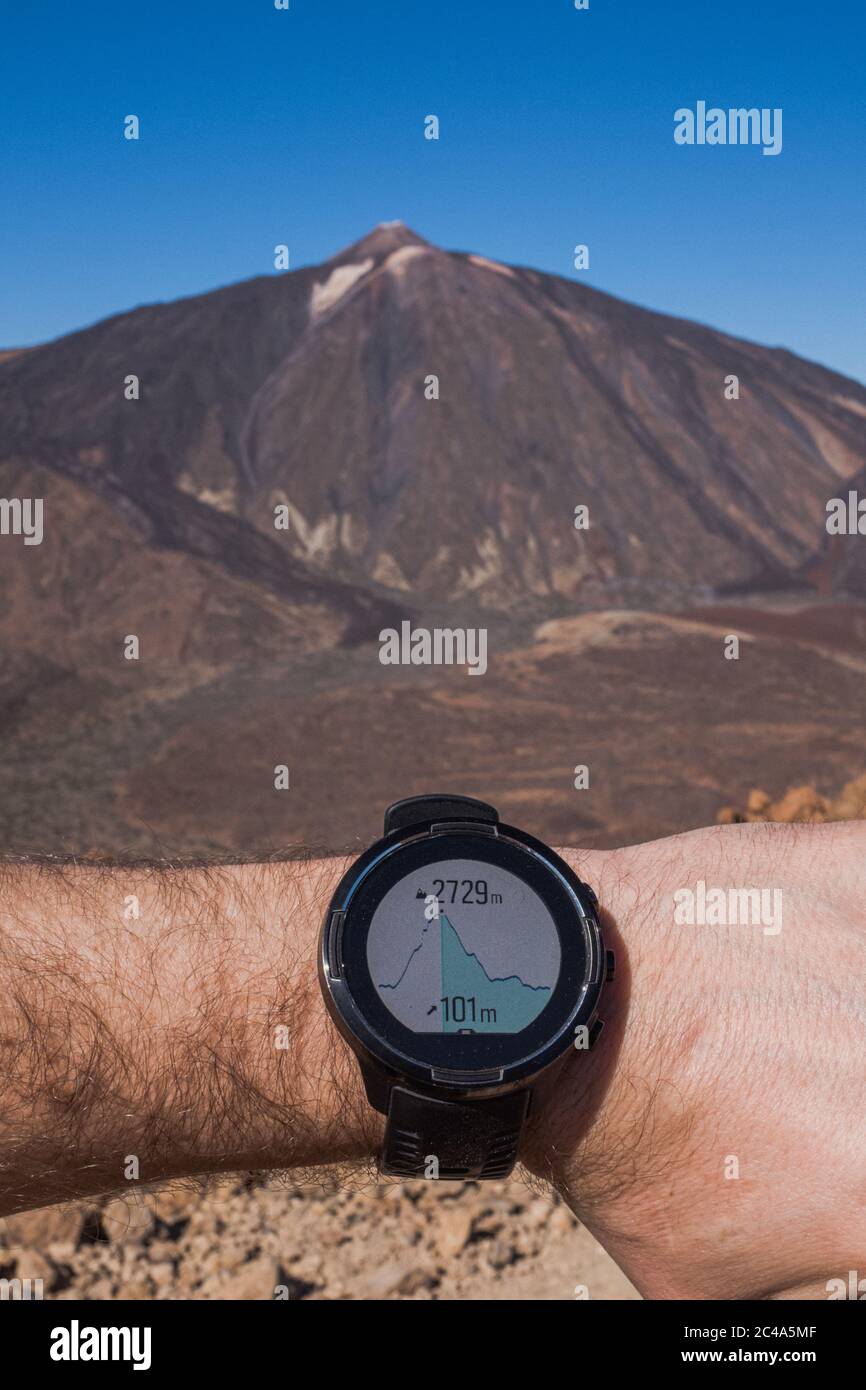 Runner checking progress on smart watch. Volcano on background Stock ...