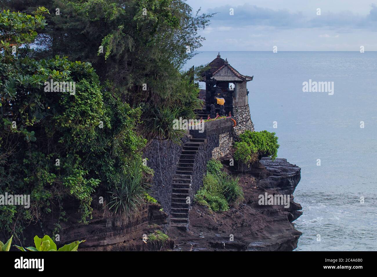 Unique architectural of a temple with a staircase by the cliff in Tanah ...