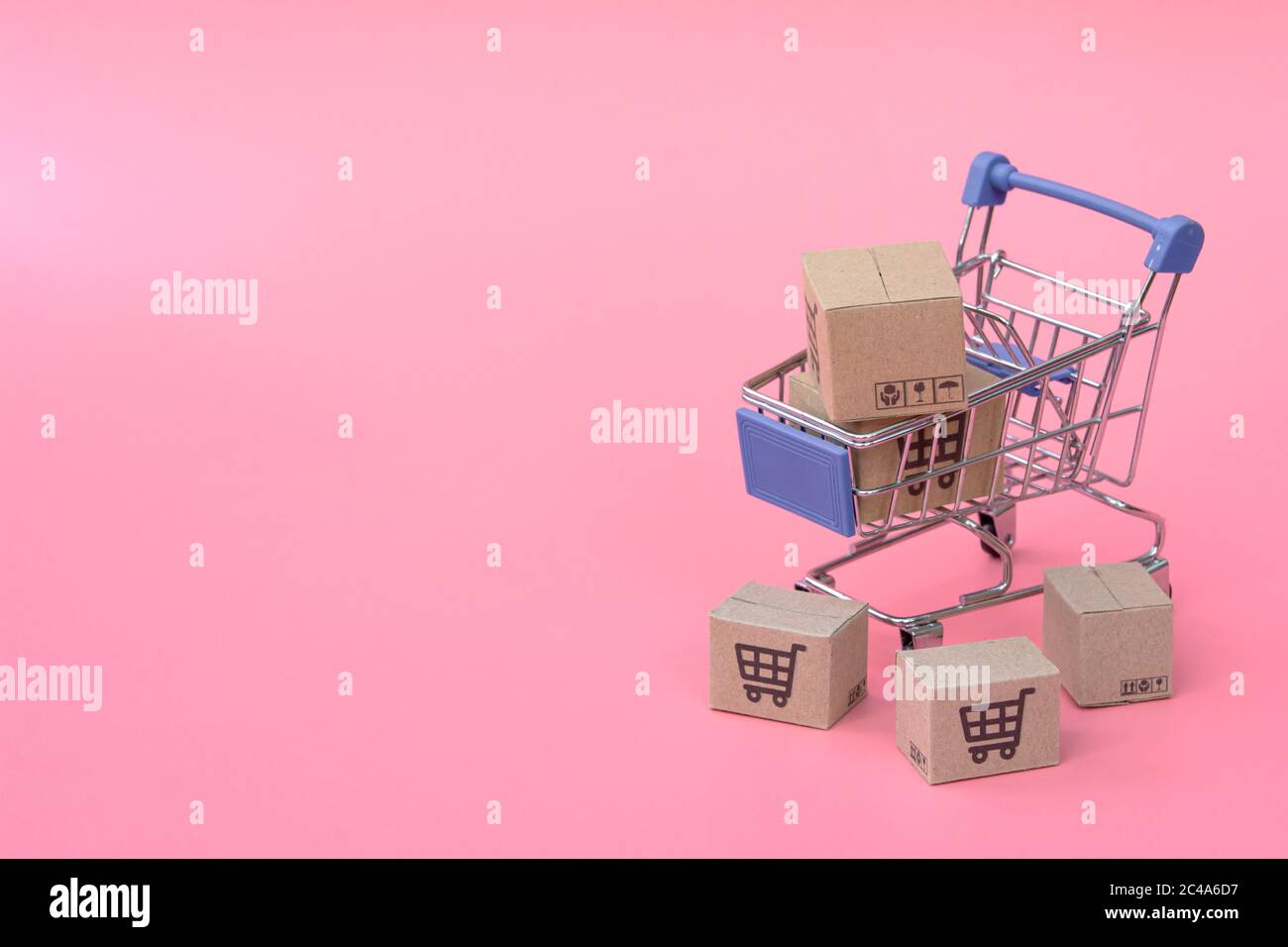 Shopping concept : Cartons or Paper boxes in blue shopping cart on pink ...