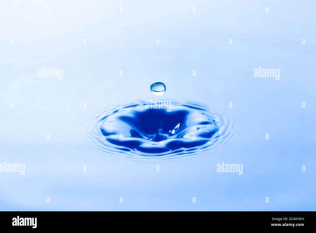 Water droplet falling impact with water surface. causing rings on water ...