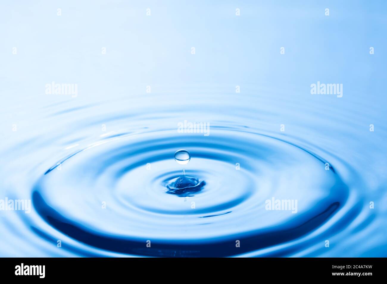 Water droplet falling impact with water surface. causing rings on water ...