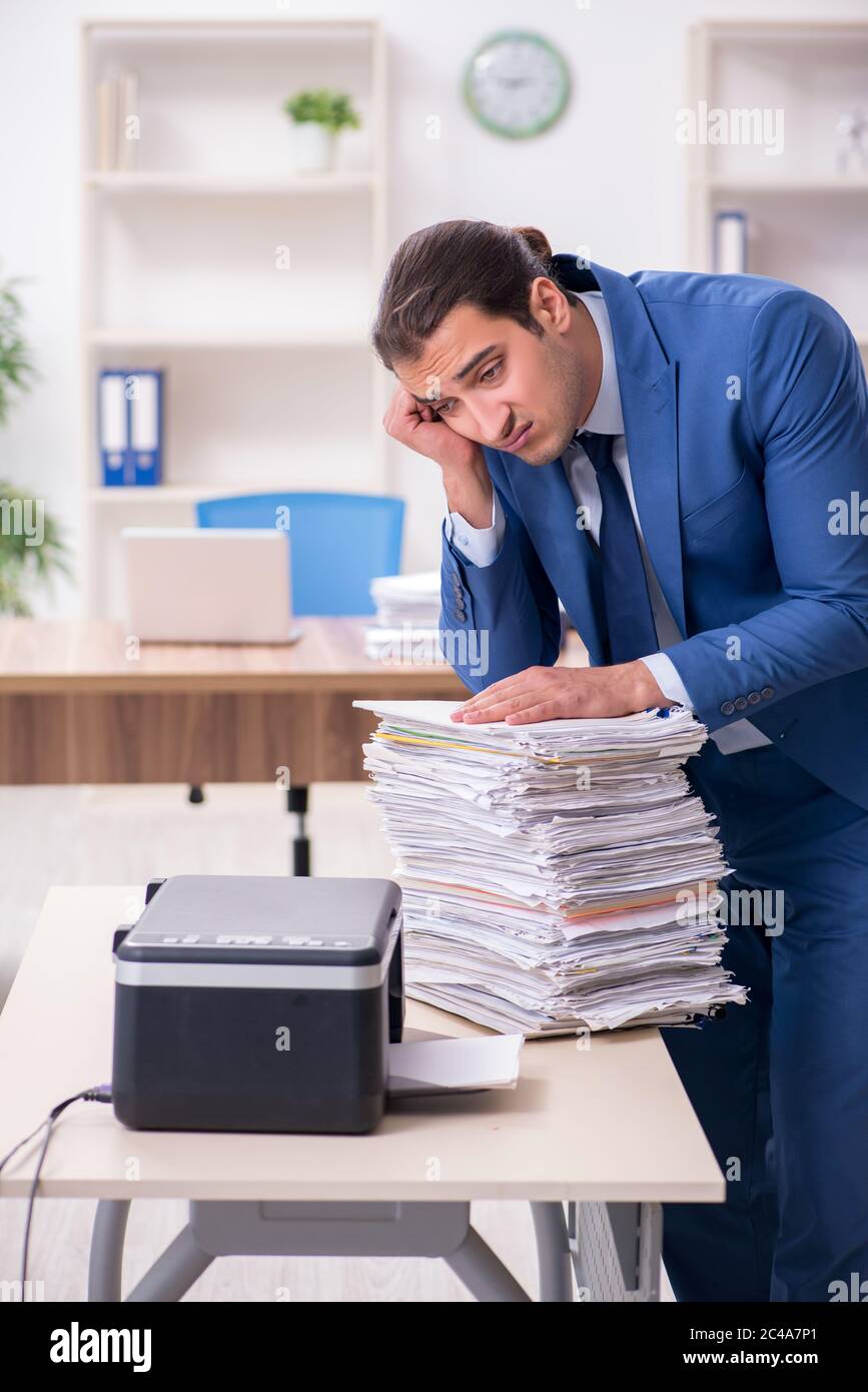 Young employee making copies at copying machine Stock Photo - Alamy