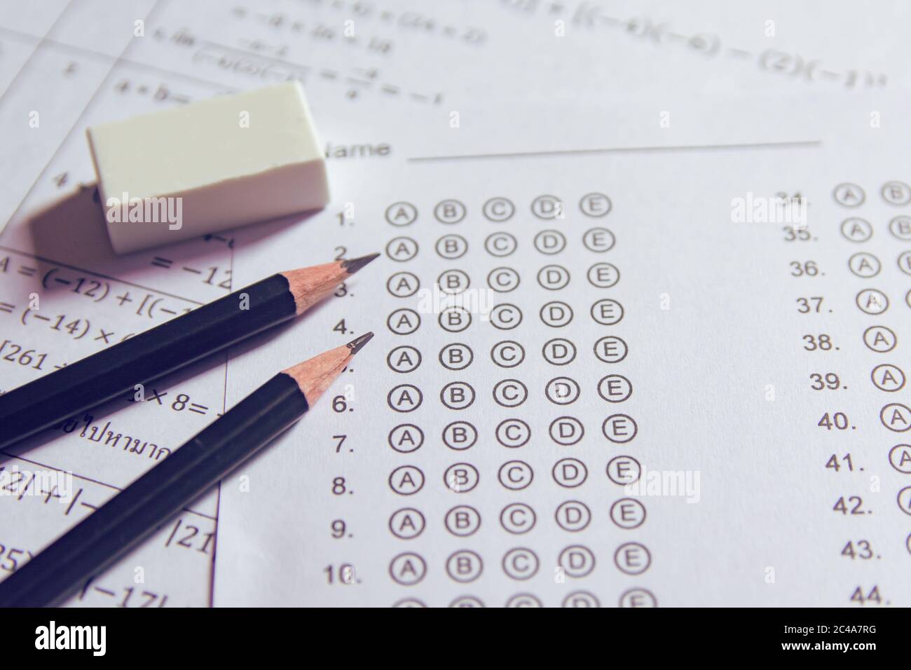 Pencil and eraser on answer sheets or Standardized test form with ...