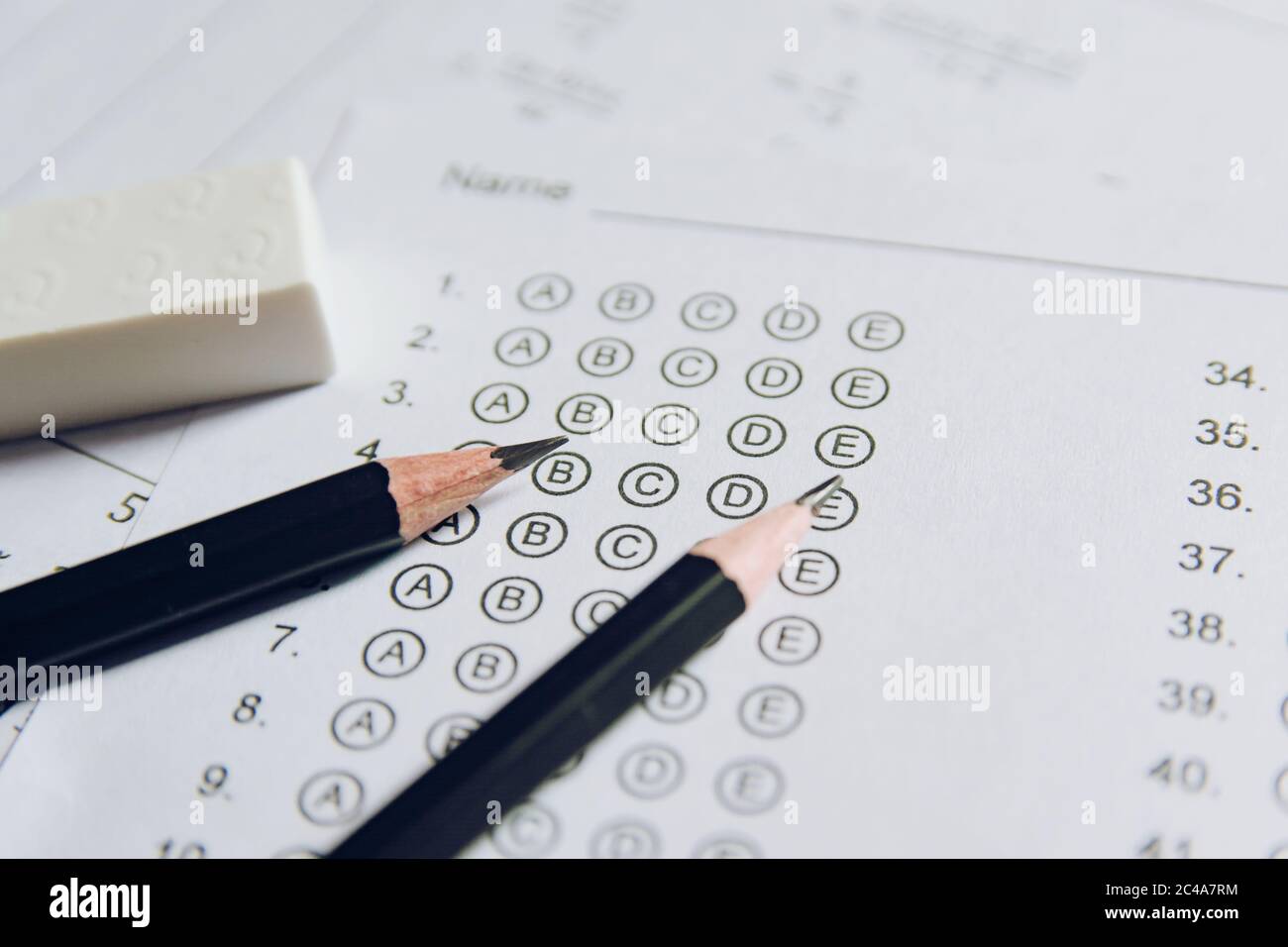Pencil and eraser on answer sheets or Standardized test form with ...