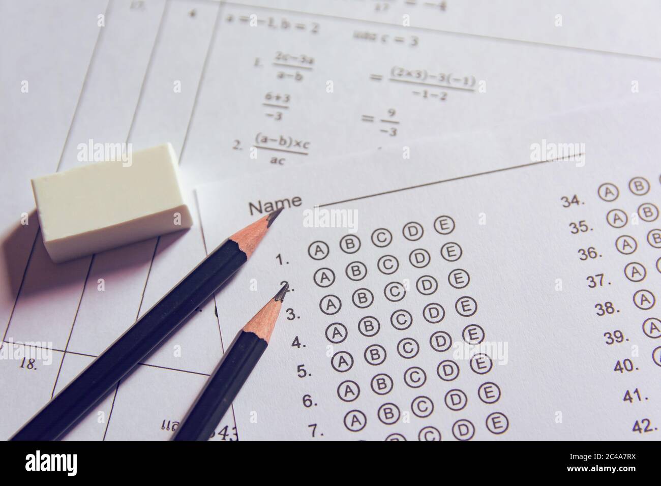 Pencil and eraser on answer sheets or Standardized test form with ...