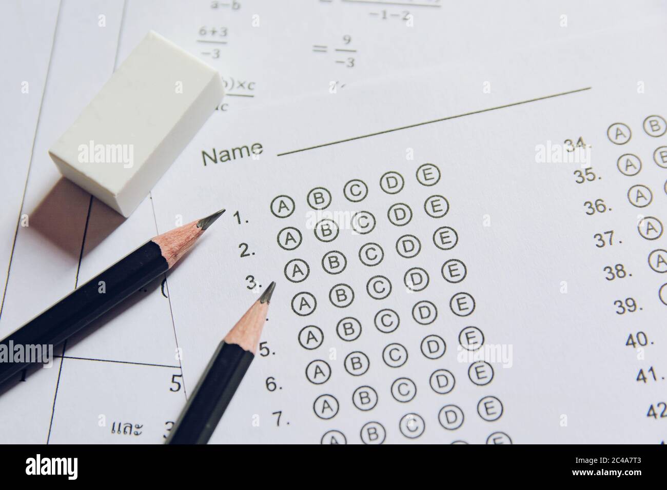 Pencil and eraser on answer sheets or Standardized test form with ...