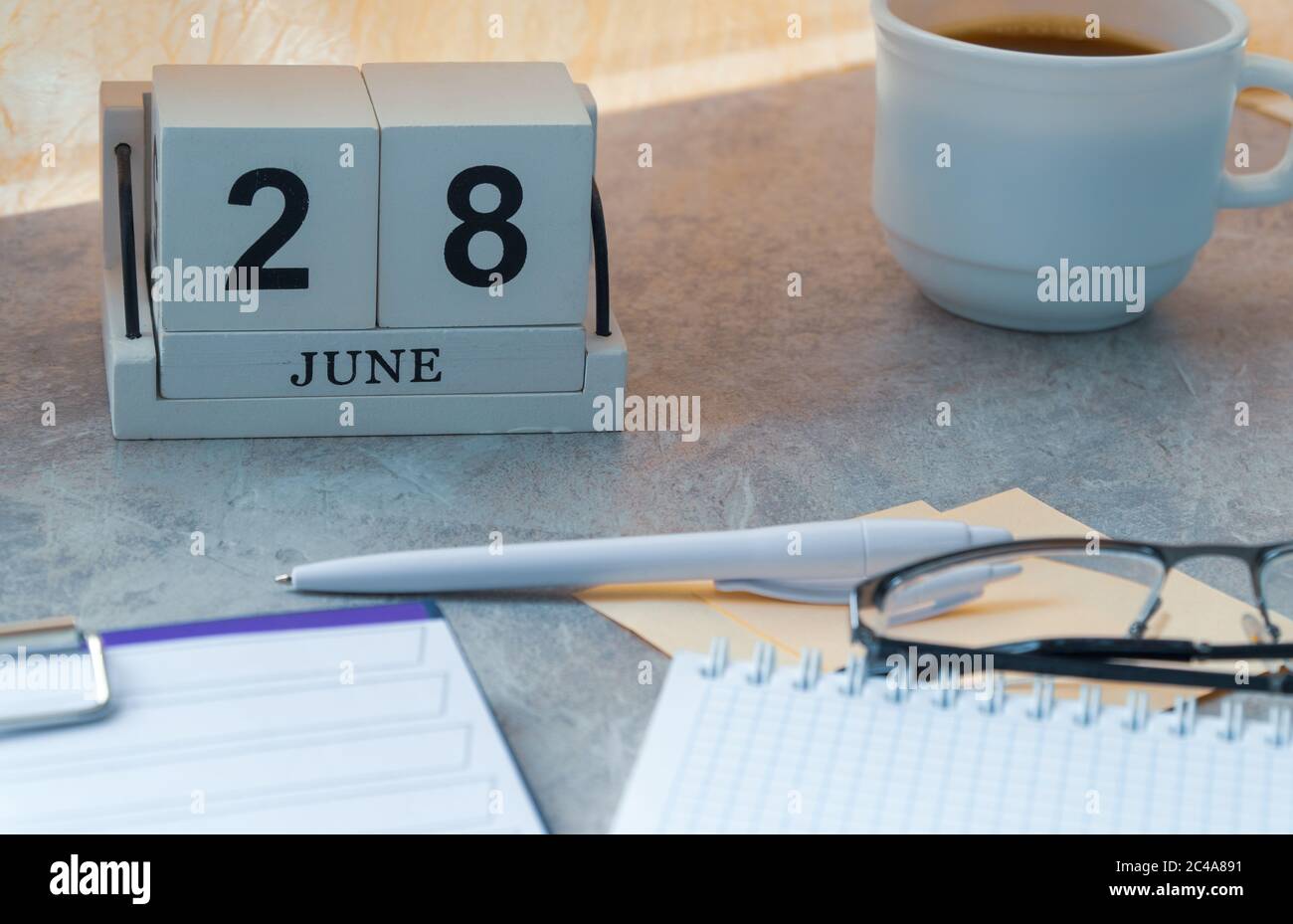 June 28, date on the calendar. Handmade wood cube with date month and ...