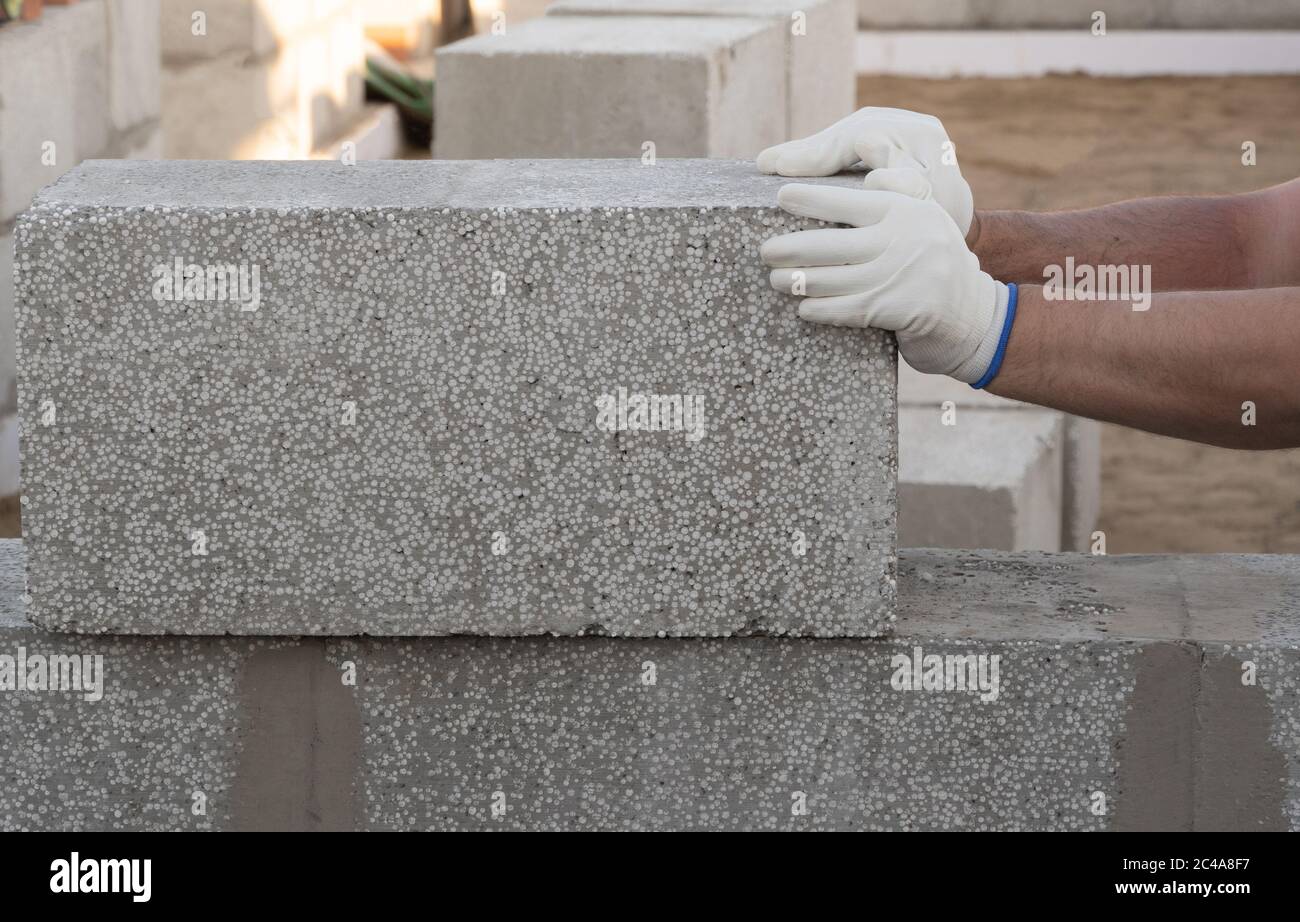 man lays stone blocks, building a house. copy space Stock Photo - Alamy