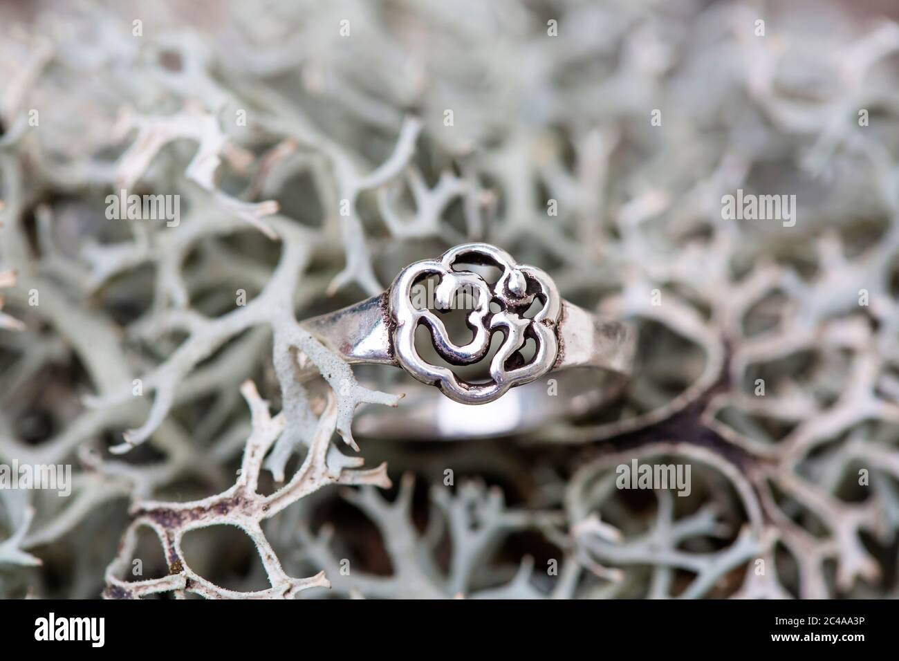 Silver metal ring in the shape of om Stock Photo - Alamy