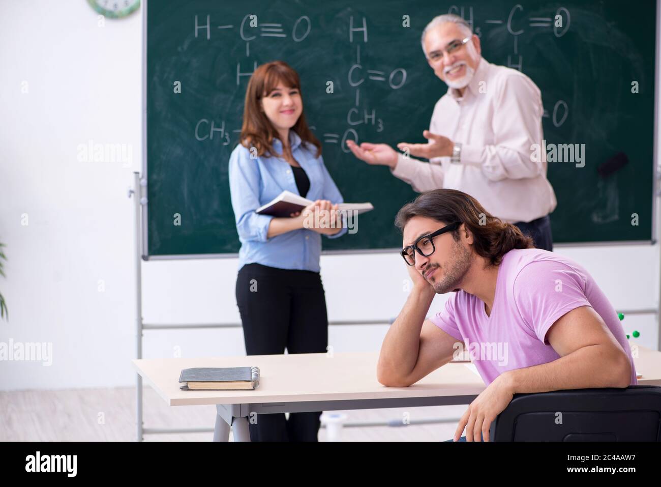 Old teacher and two students in the classroom Stock Photo - Alamy