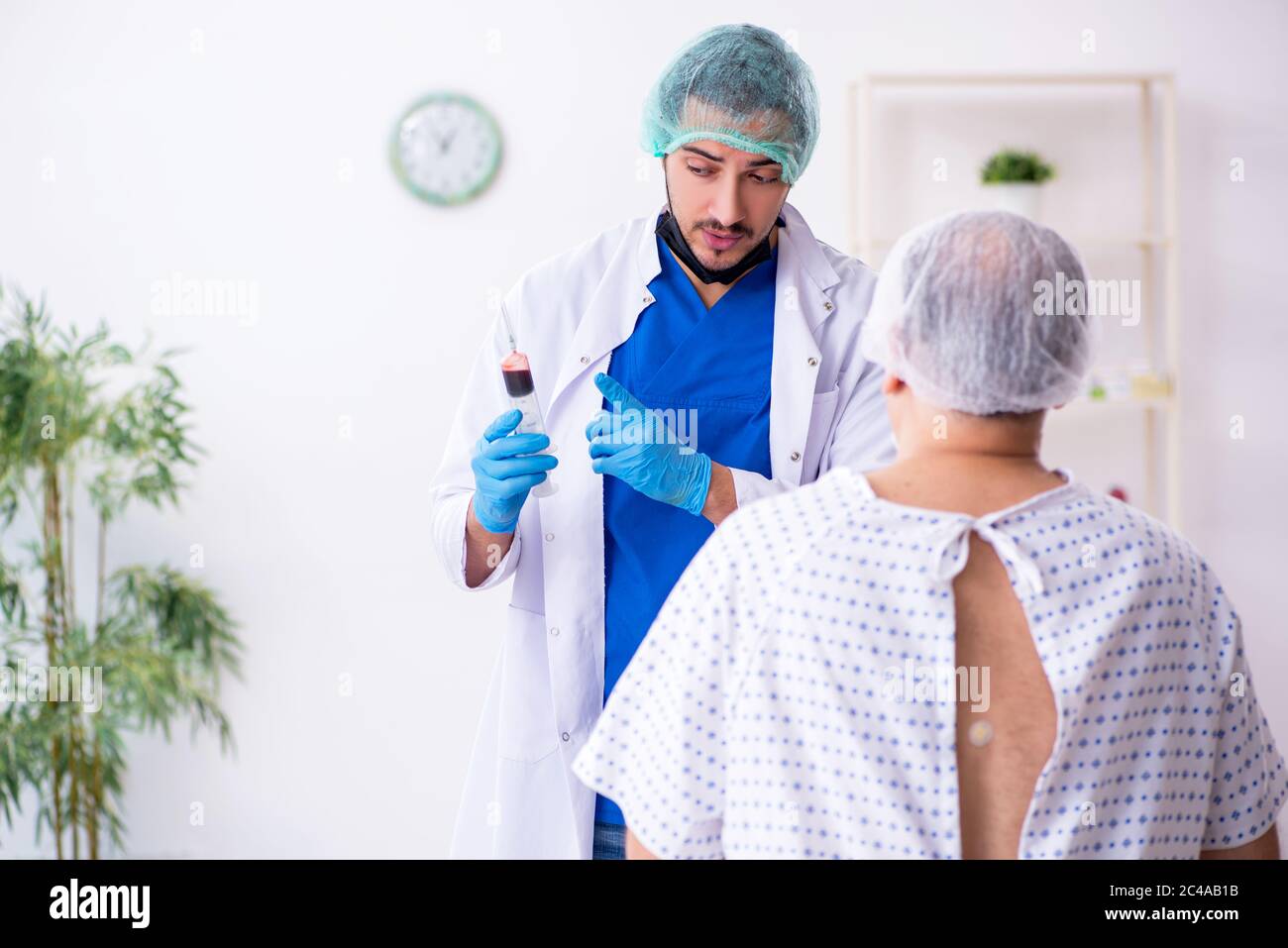 Old man visiting young intern doctor Stock Photo - Alamy