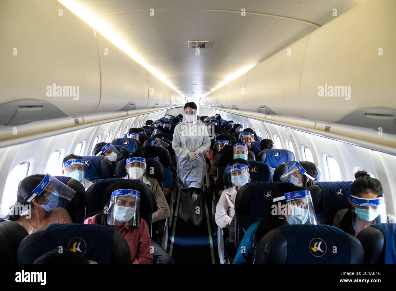 An air hostess of Buddha Air wearing a protective suit attends to ...
