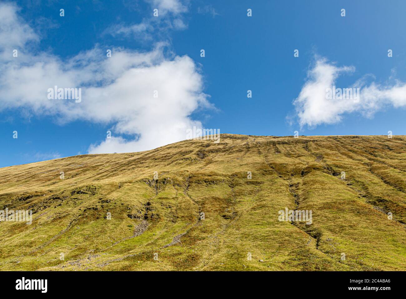 Looking up at a rugged mountain in the Scottish Highlands, with a blue ...