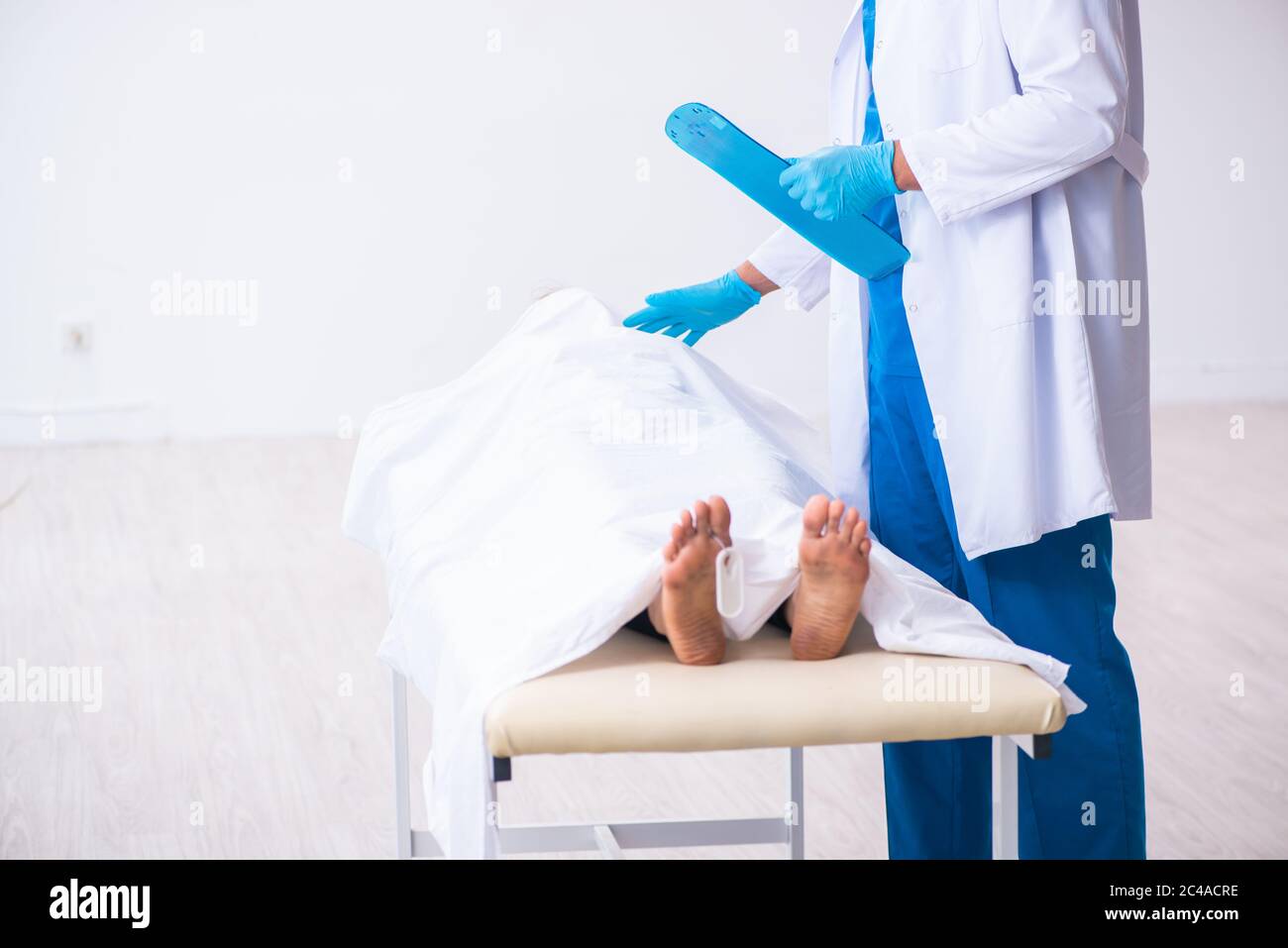 Police coroner examining dead body in morgue Stock Photo - Alamy