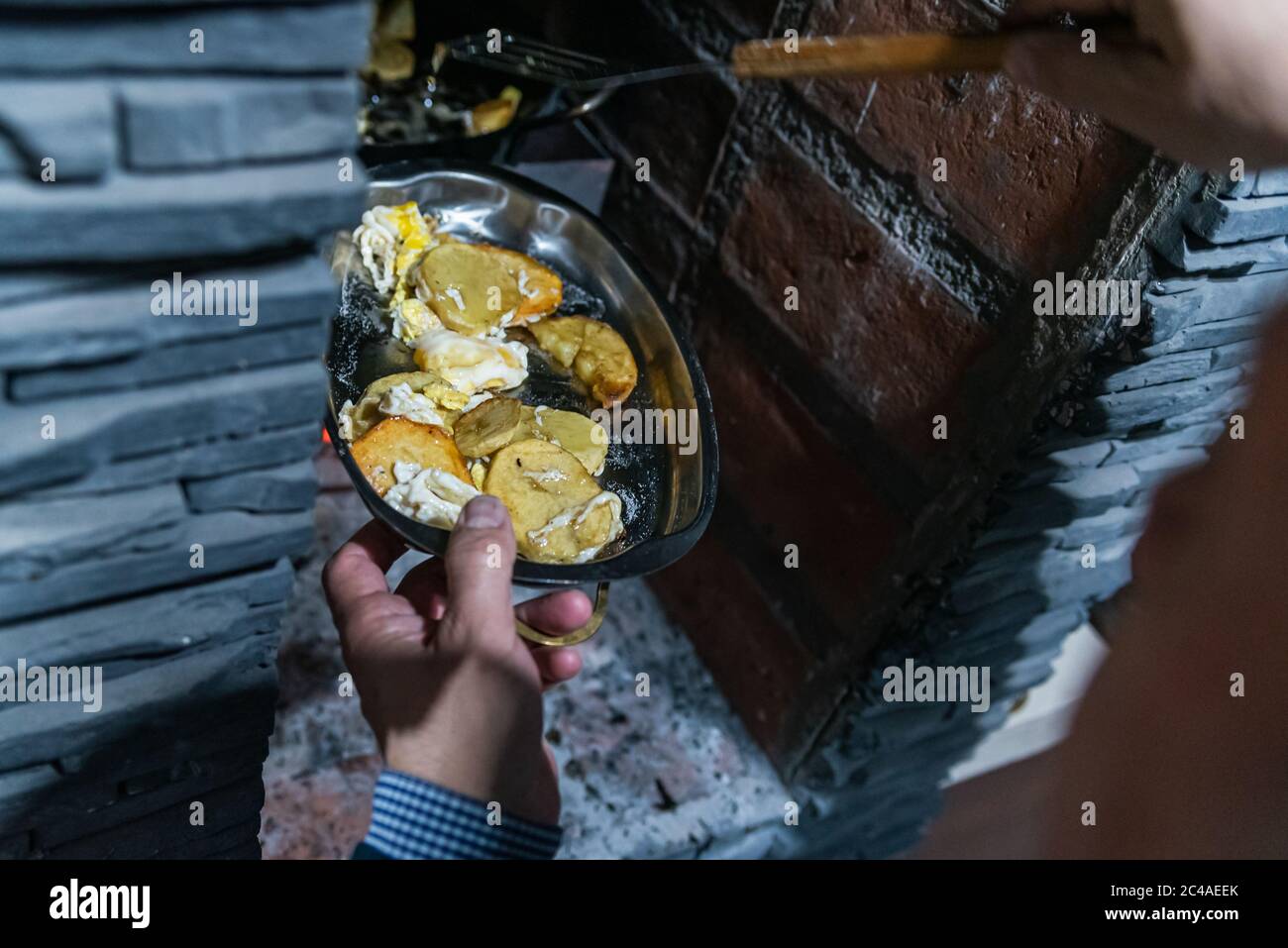 man cooking fried eggs with potatoes in frying pan, top view, selective ...