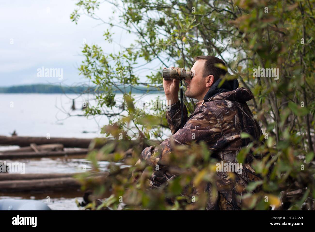 Hunter looking through binoculars Stock Photo - Alamy